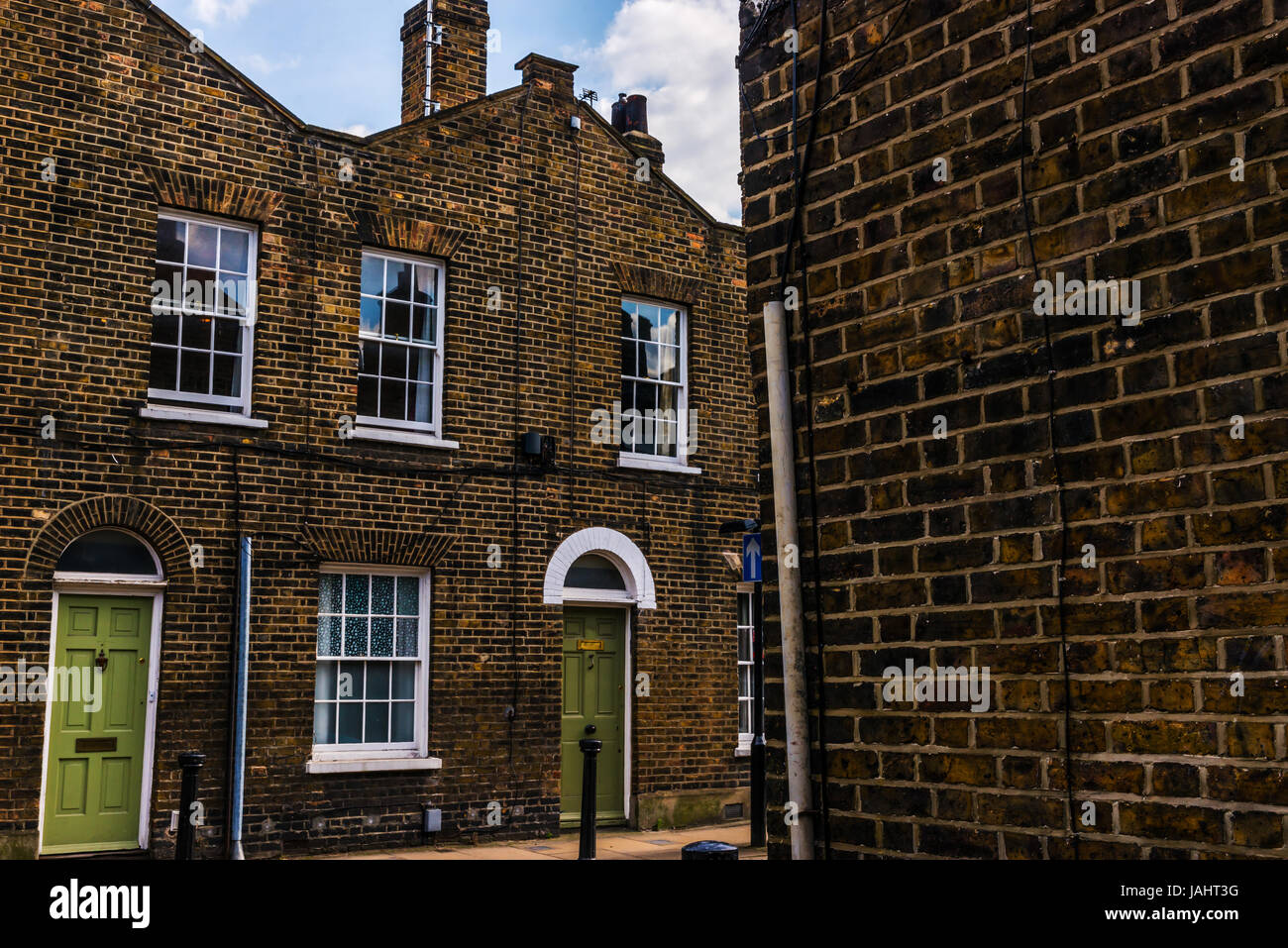 Typical old English buildings, low brick buildings across a narrow ...