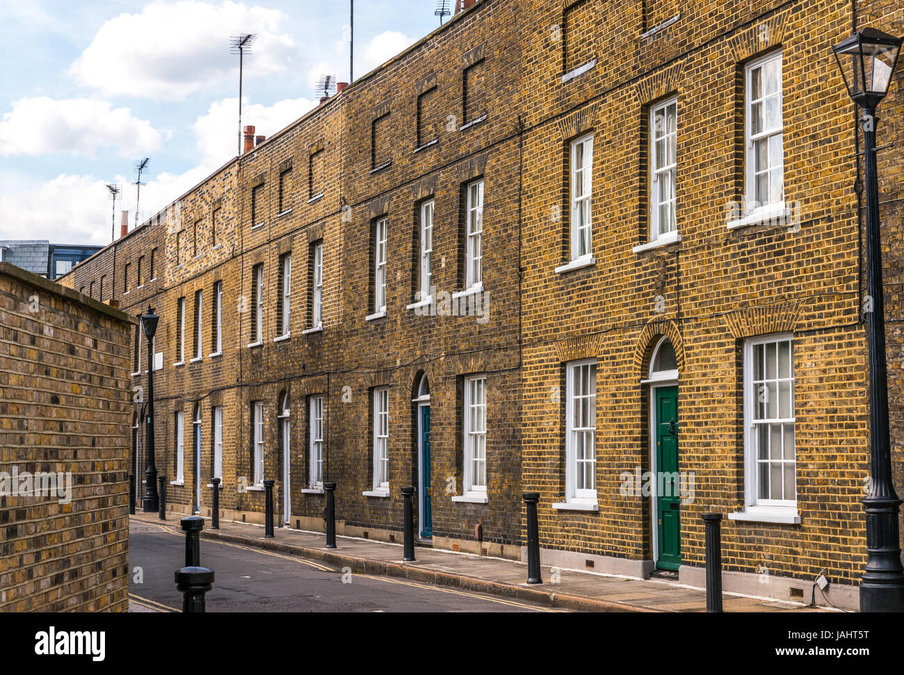 Typical old English buildings, low brick buildings across a narrow ...