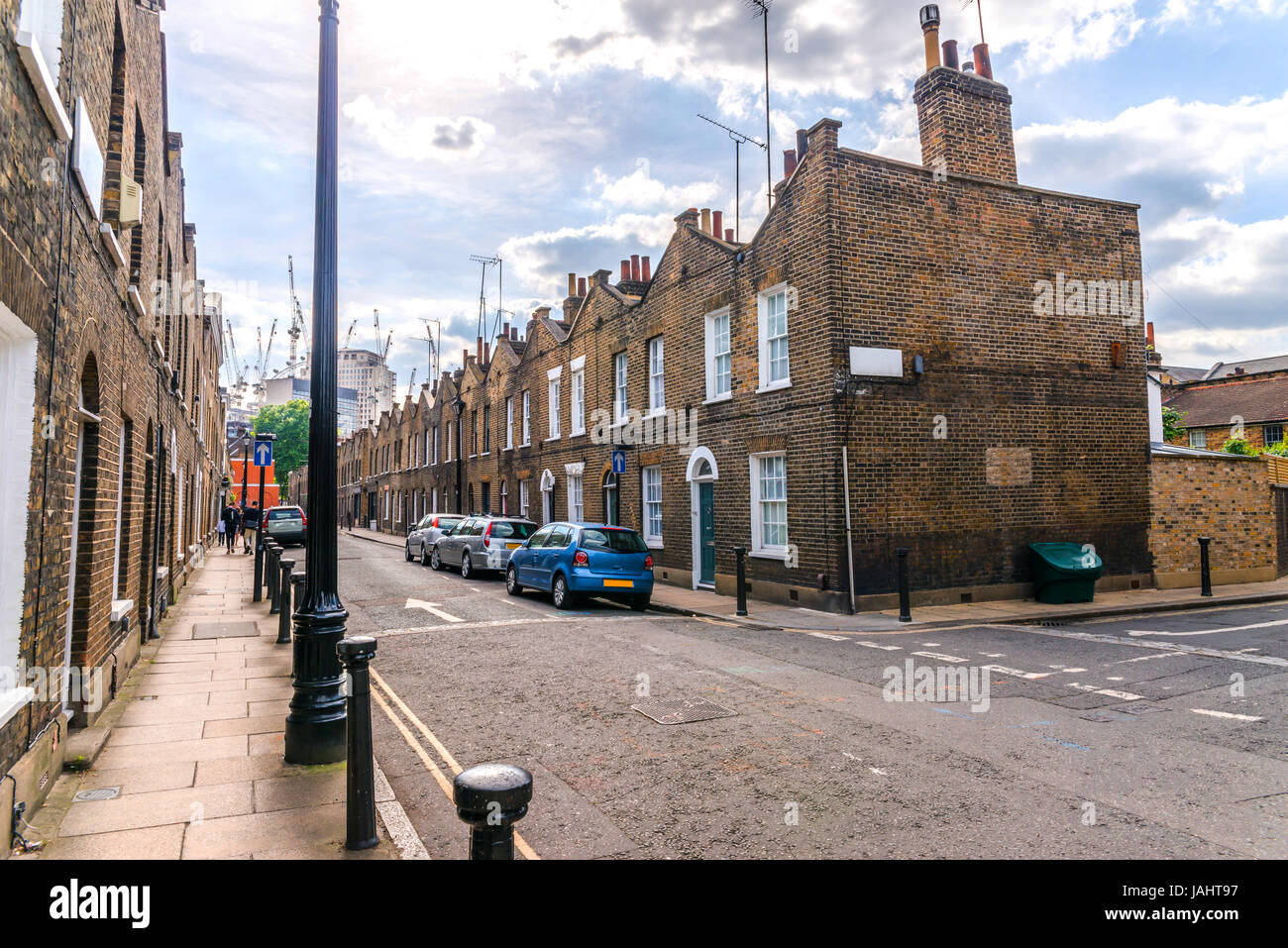 Typical old English buildings, low brick buildings across a narrow ...
