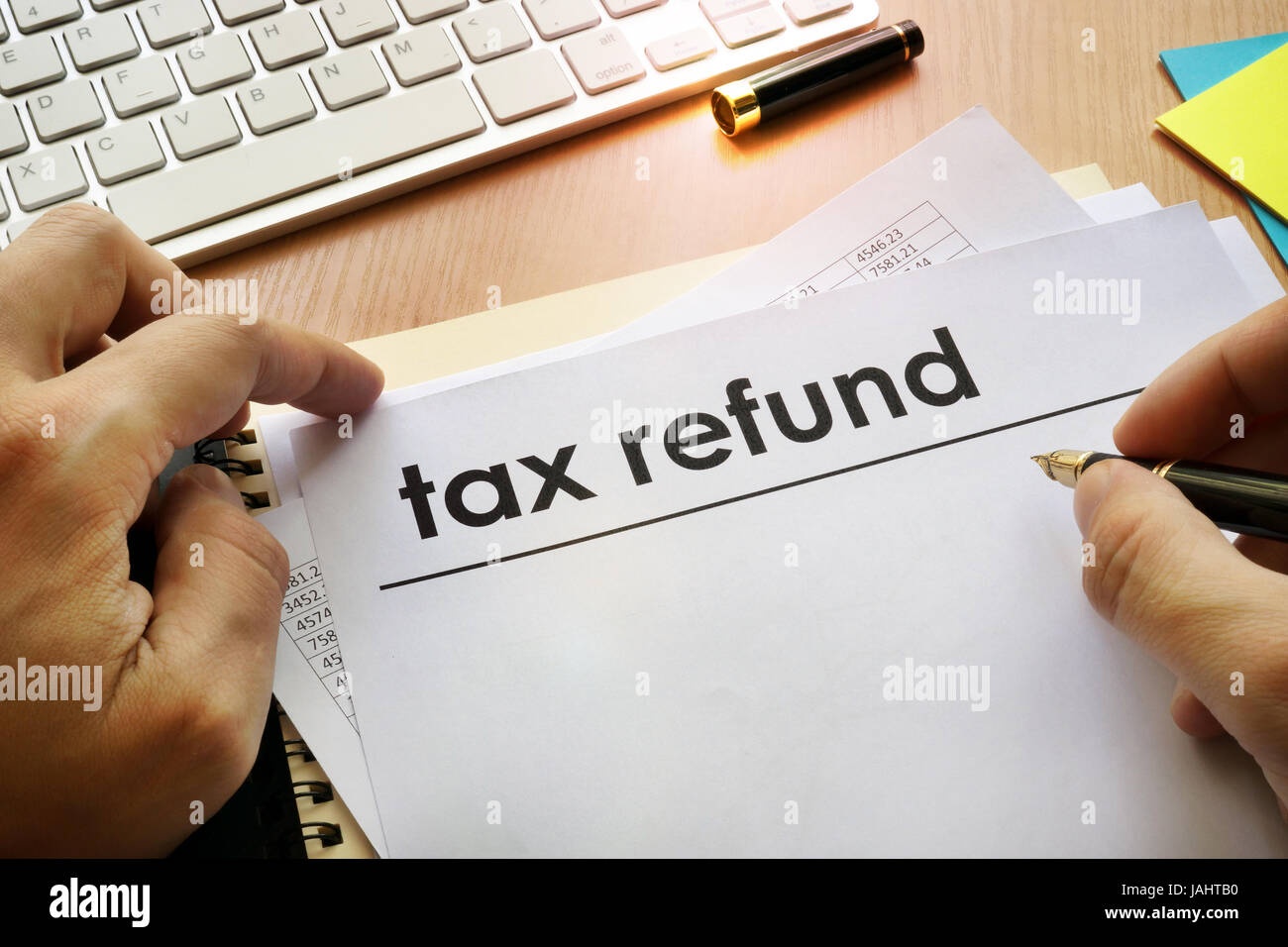 Hands holding documents with title tax refund Stock Photo - Alamy