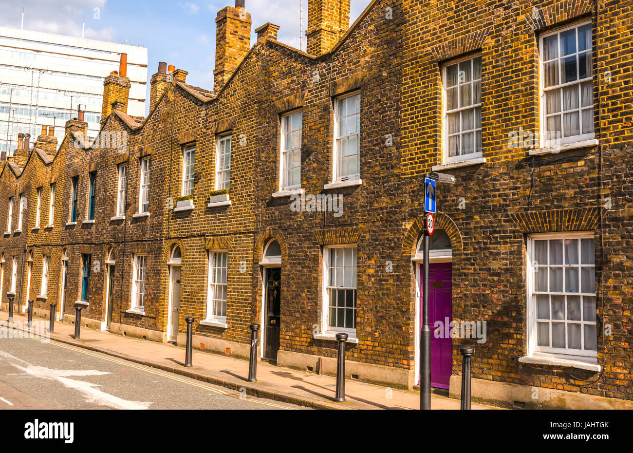 Typical old English buildings, low brick buildings across a narrow ...