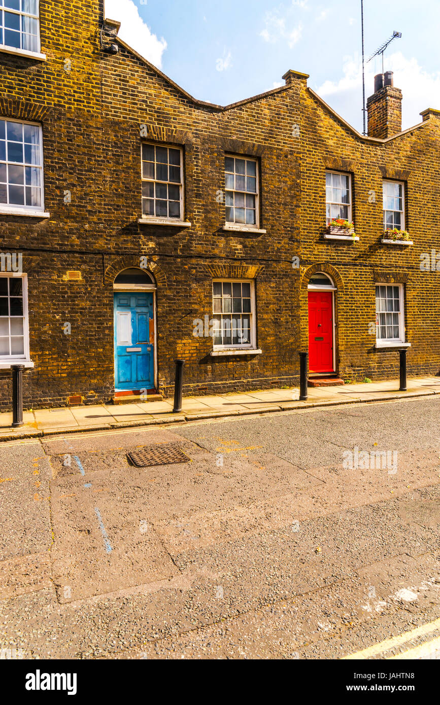 Typical old English buildings, low brick buildings across a narrow ...