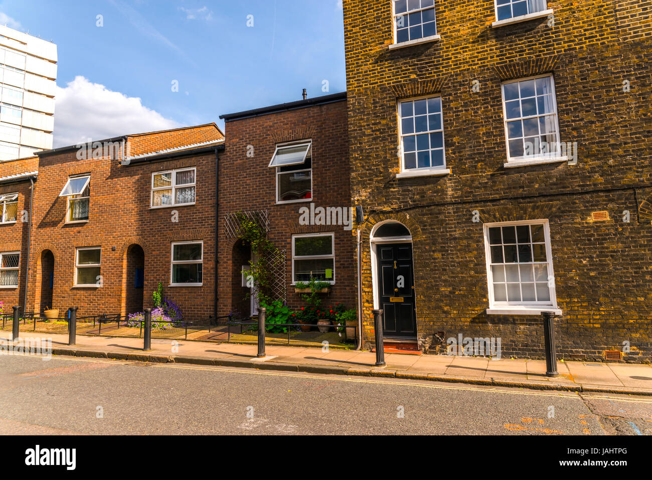 Typical old English buildings, low brick buildings across a narrow ...