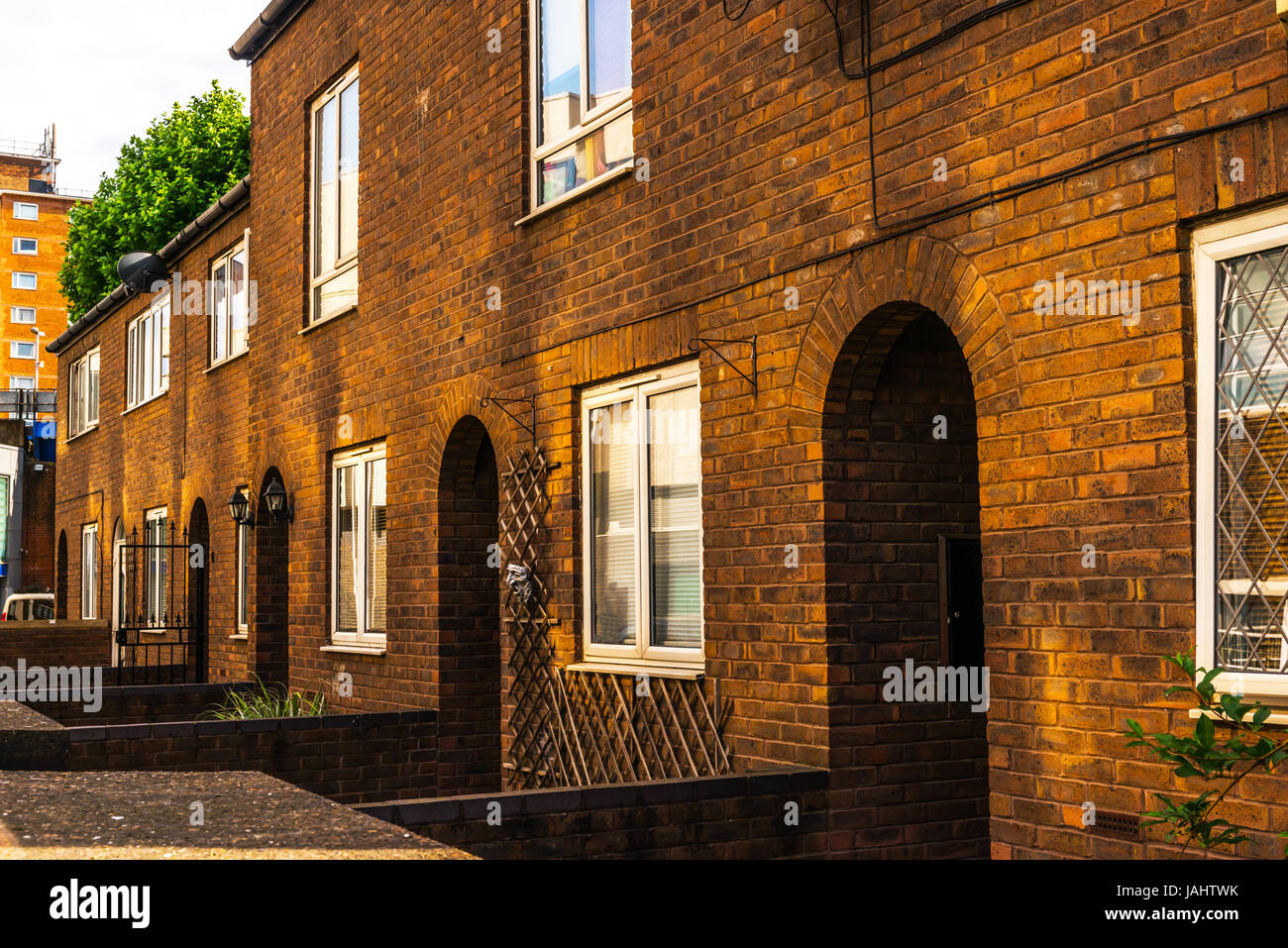 Typical old English buildings, low brick buildings across a narrow ...