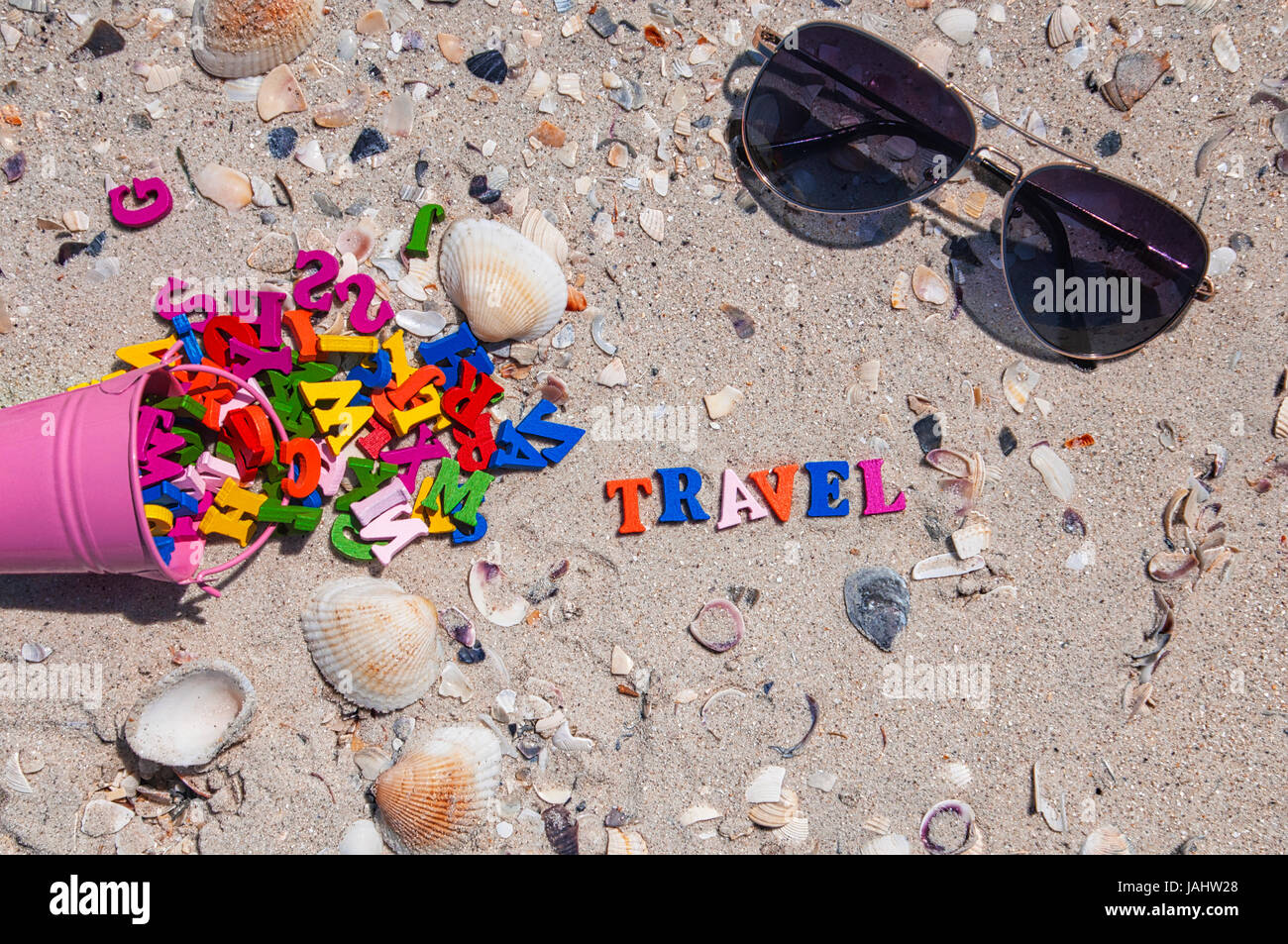 Word travel of wooden colorful letters on a sandy beach, near black ...