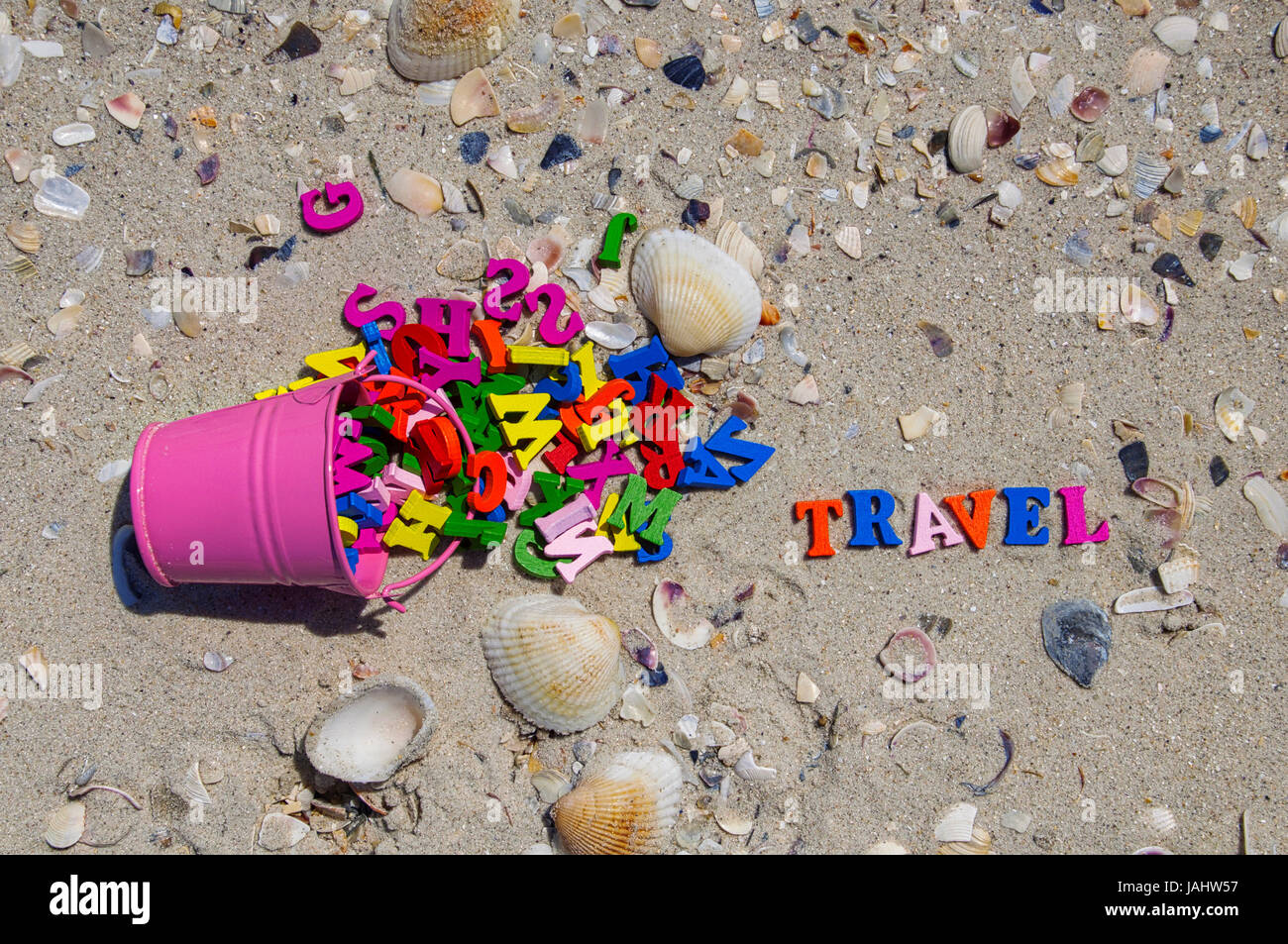 Multicolored wooden letters in a pink iron bucket are scattered on the ...
