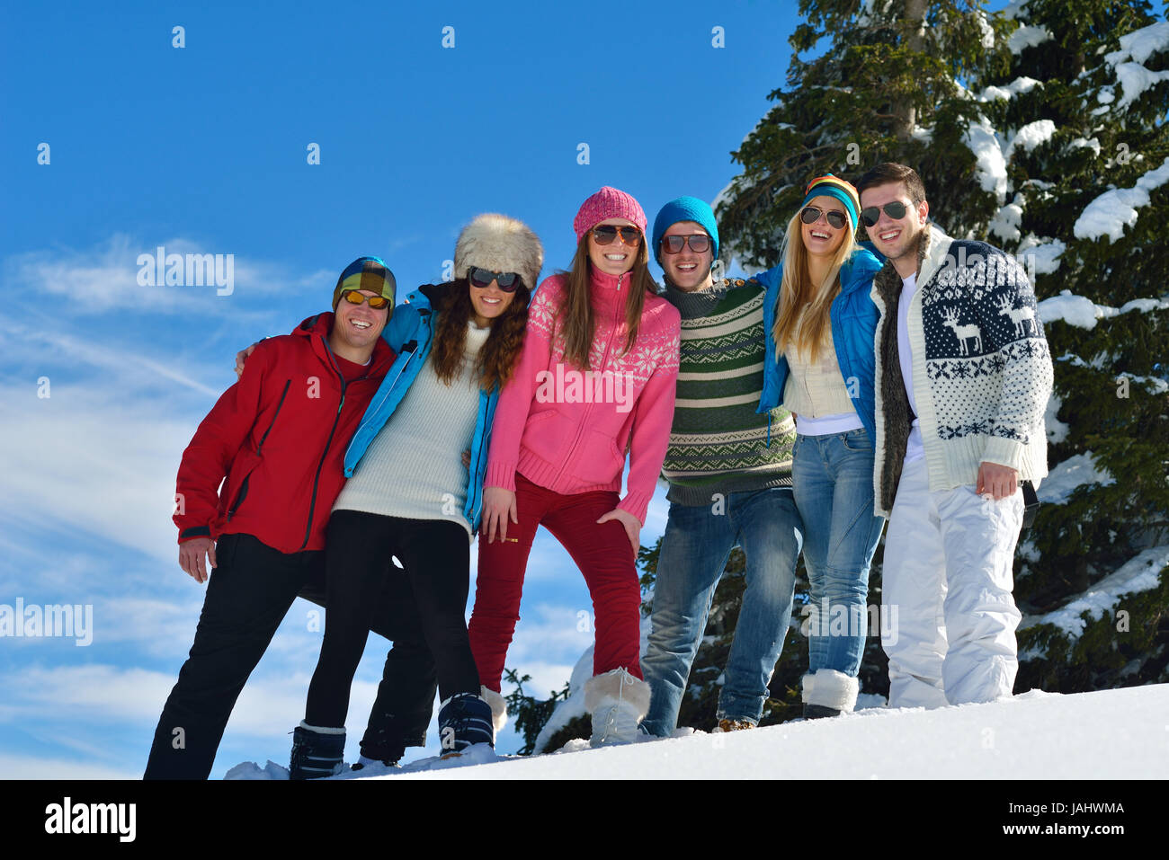 happy young people group have fun and enjoy fresh snow at beautiful ...