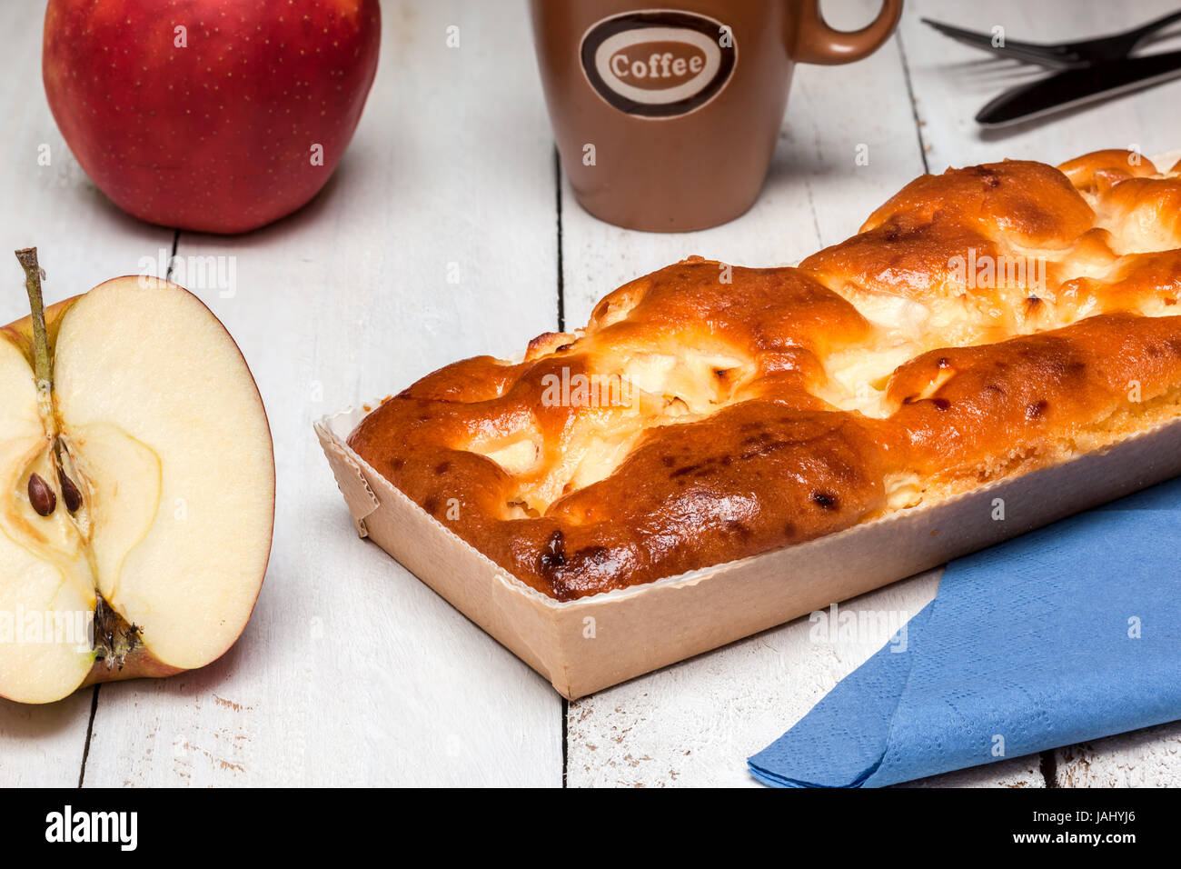 An elongated apple cake with coffee and Cutlery Stock Photo - Alamy