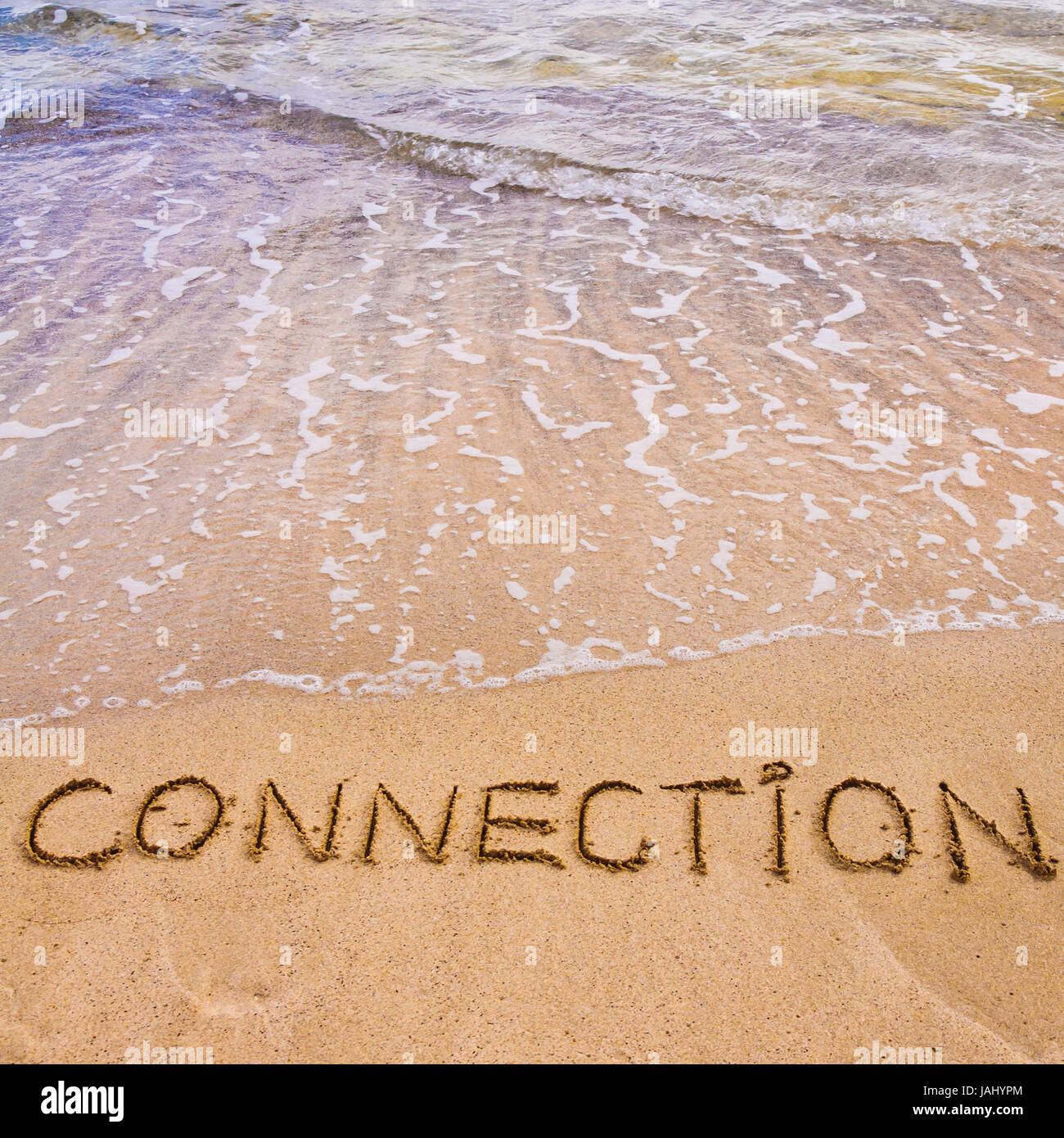 Connection word written on sand, with waves in background, connecting ...