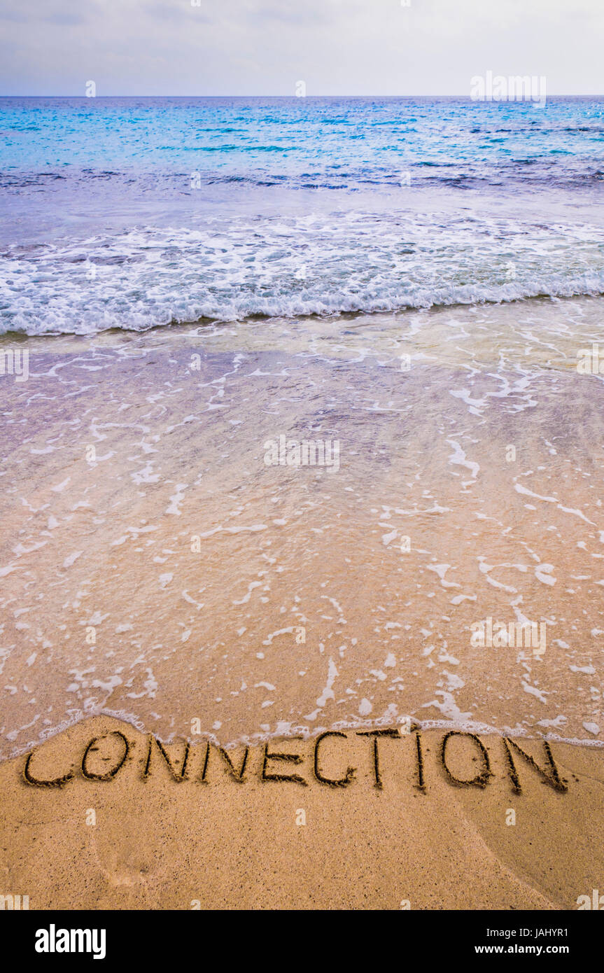 Connection word written on sand, with waves in background, connecting ...