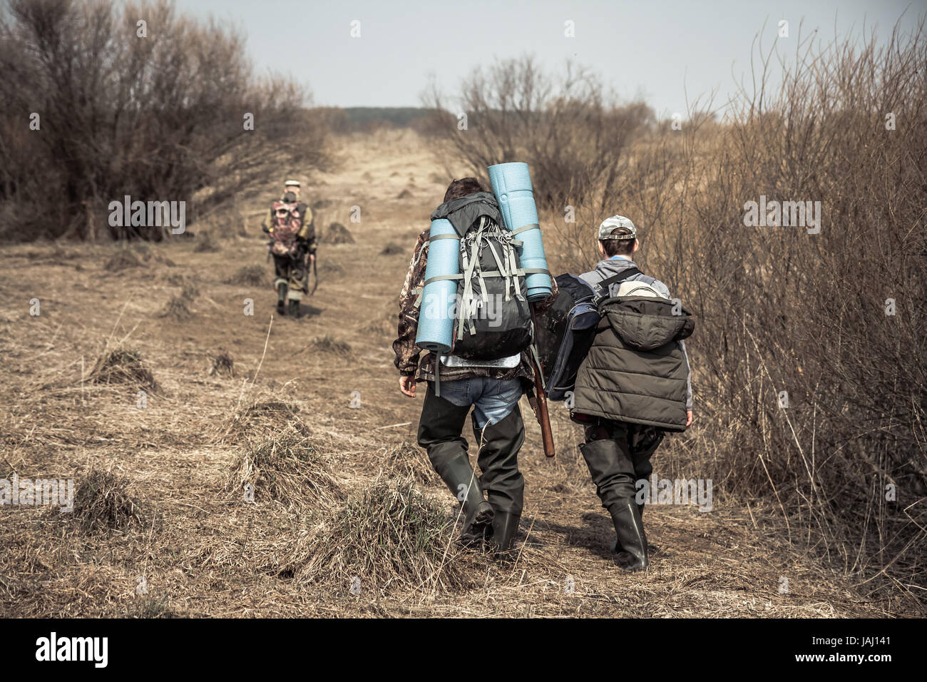 Hunting scene with hunters with backpacks and hunting ammunition going ...