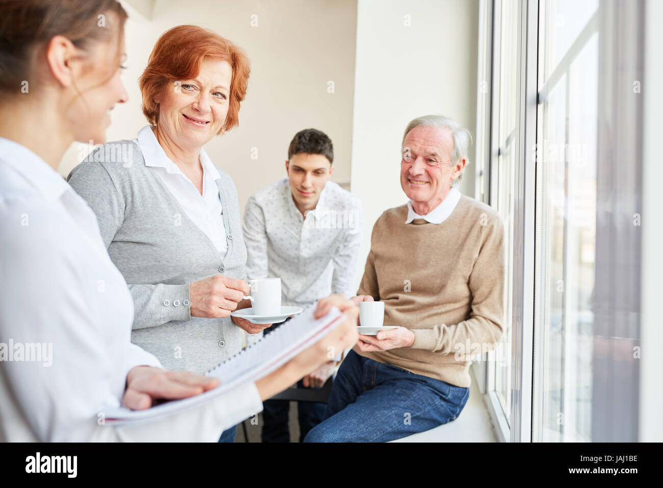 Seniors and young business people making small talk during coffee break ...