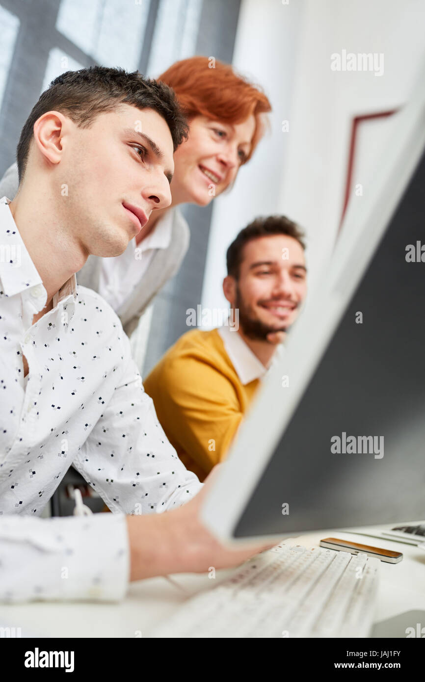 IT consultat helping with computer in internet workshop Stock Photo - Alamy