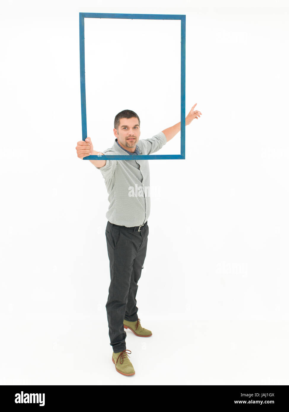 front view of caucasian man standing and holding up a wooden frame and ...