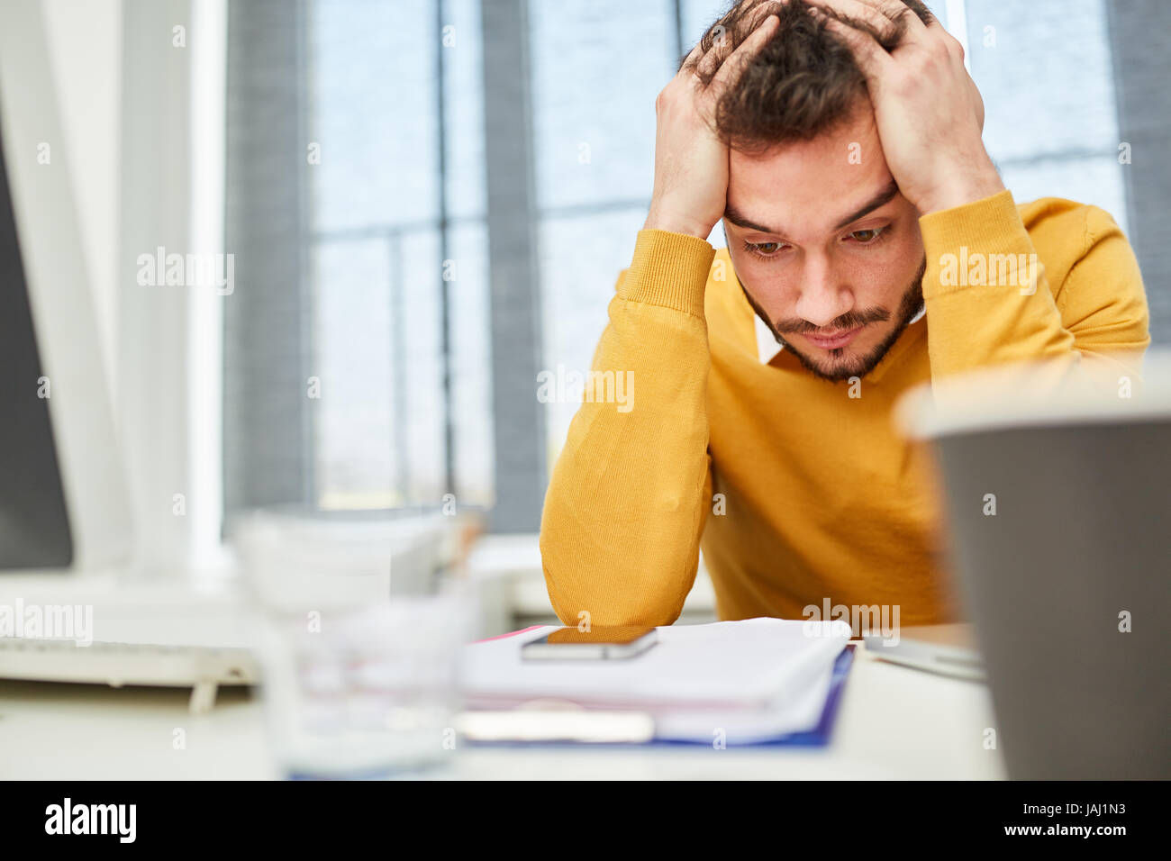 Stressed man with a crisis or problem in his office Stock Photo - Alamy