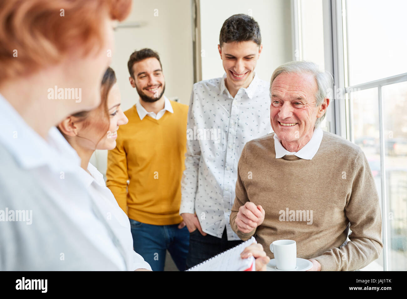 Students and seniors making small talk in workshop break Stock Photo ...