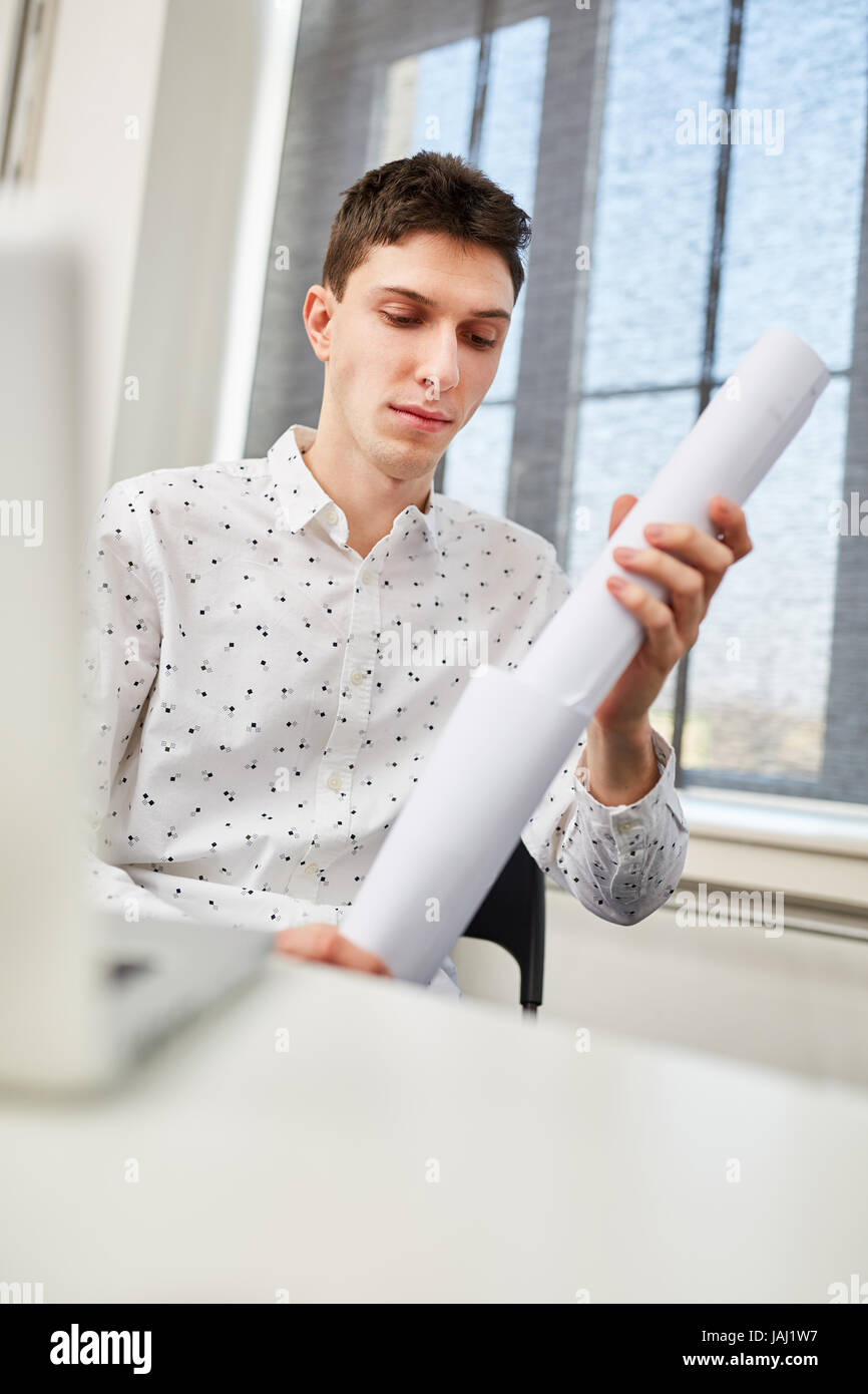 Student as architect apprenticeship trainee holding drawing in office ...