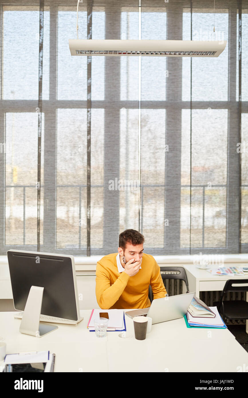 Man with computer thinks about problem and decision making solutions ...