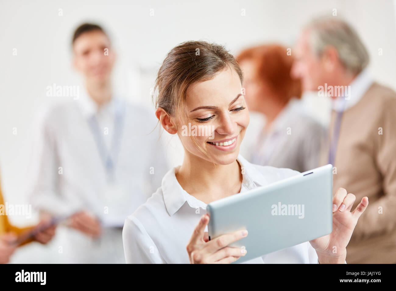 Young business woman with tablet computer writing digital message ...