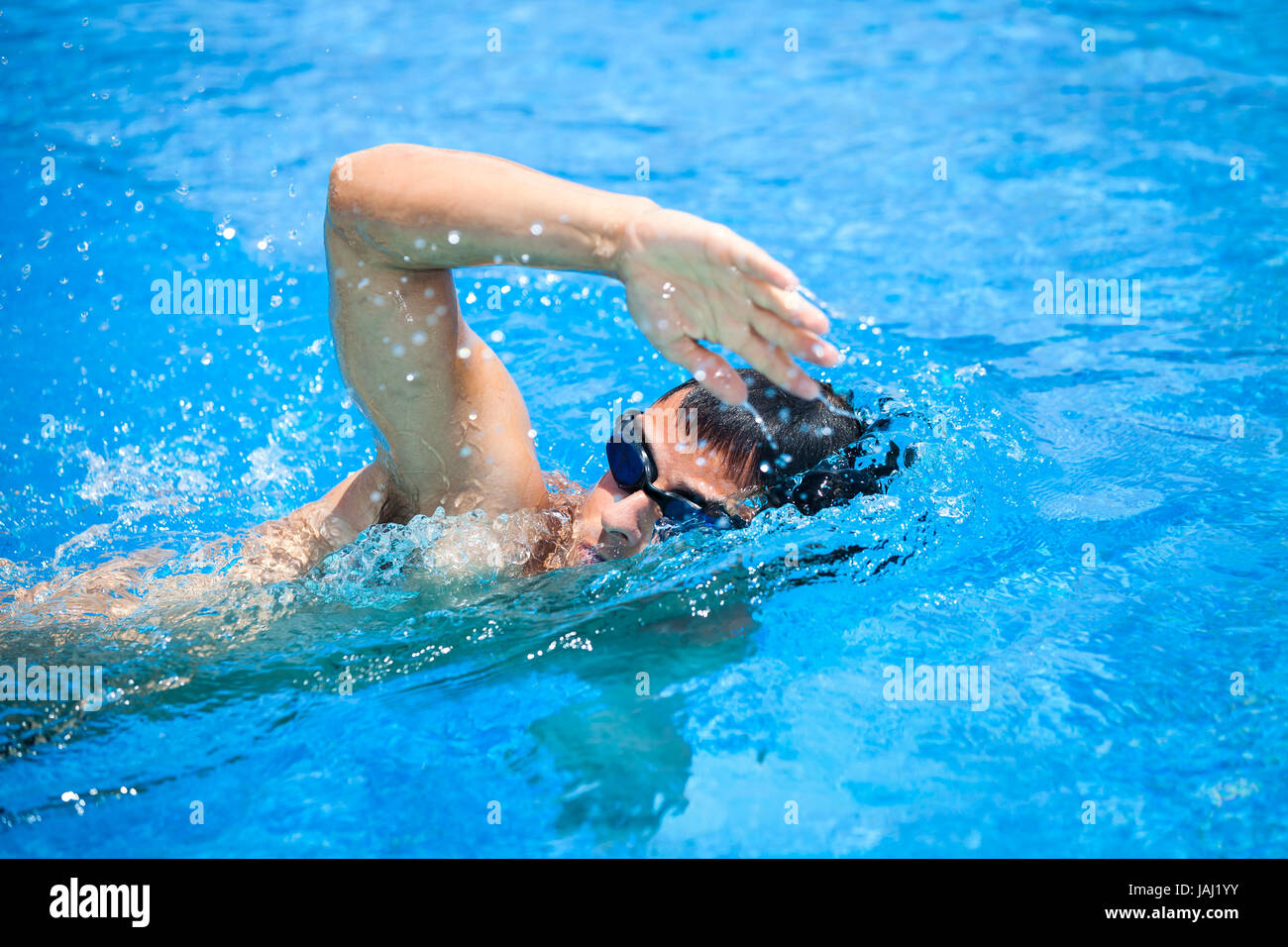 Young man swimming the front crawl in a pool Stock Photo - Alamy