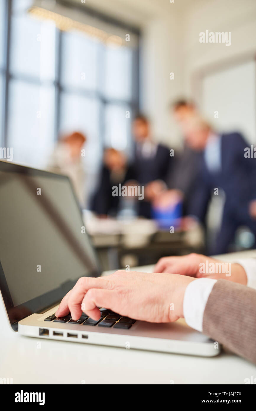 Man typing on laptop computer in business meeting Stock Photo - Alamy