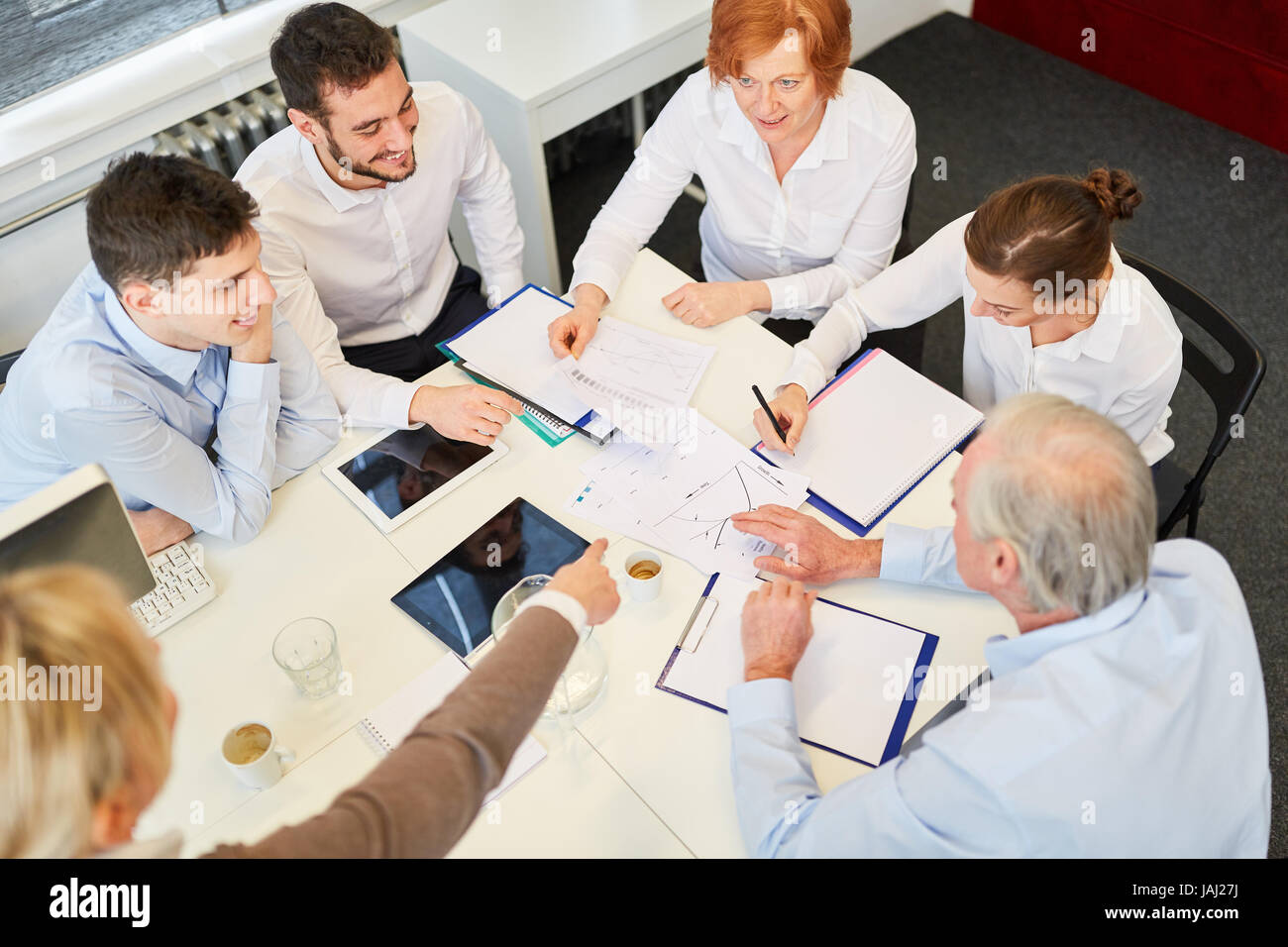 Team sitting together in business meeting and planning Stock Photo - Alamy