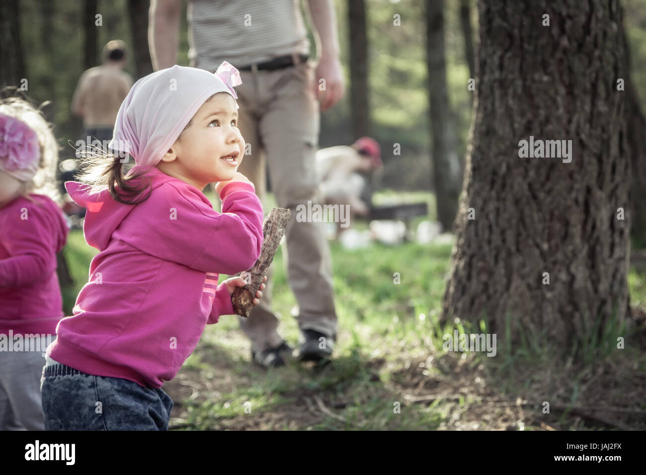 Playful child playing outdoors in summer forest during weekend holidays ...