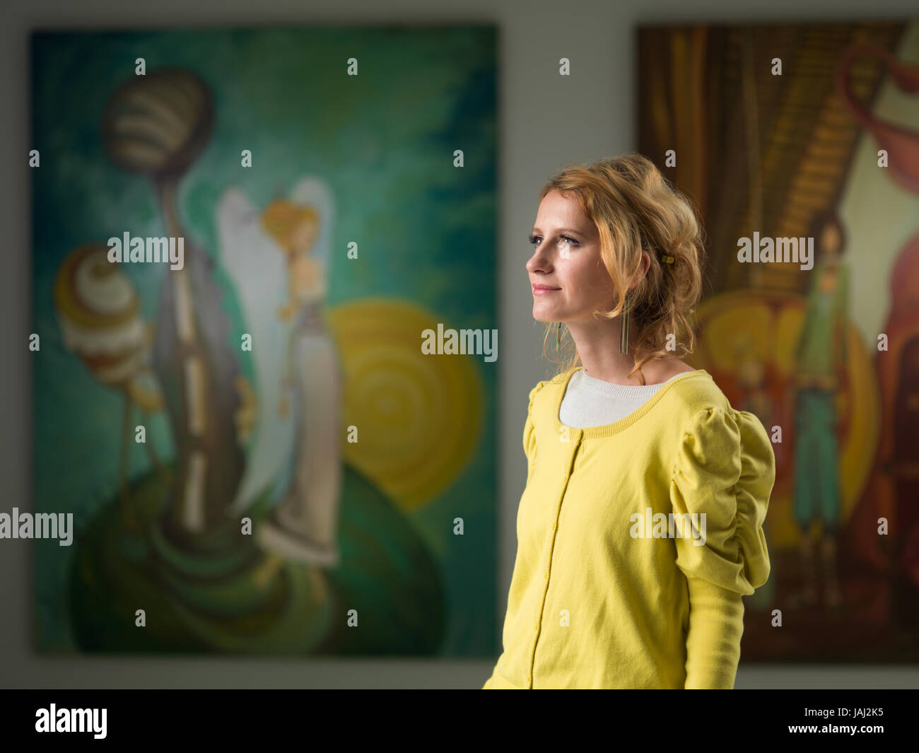 side view of beautiful caucasian woman contemplating artworks in an art ...