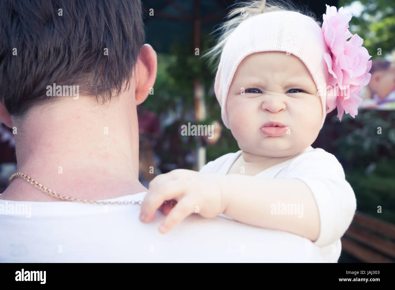 Father embracing his cute little baby. Father is looking away, baby ...