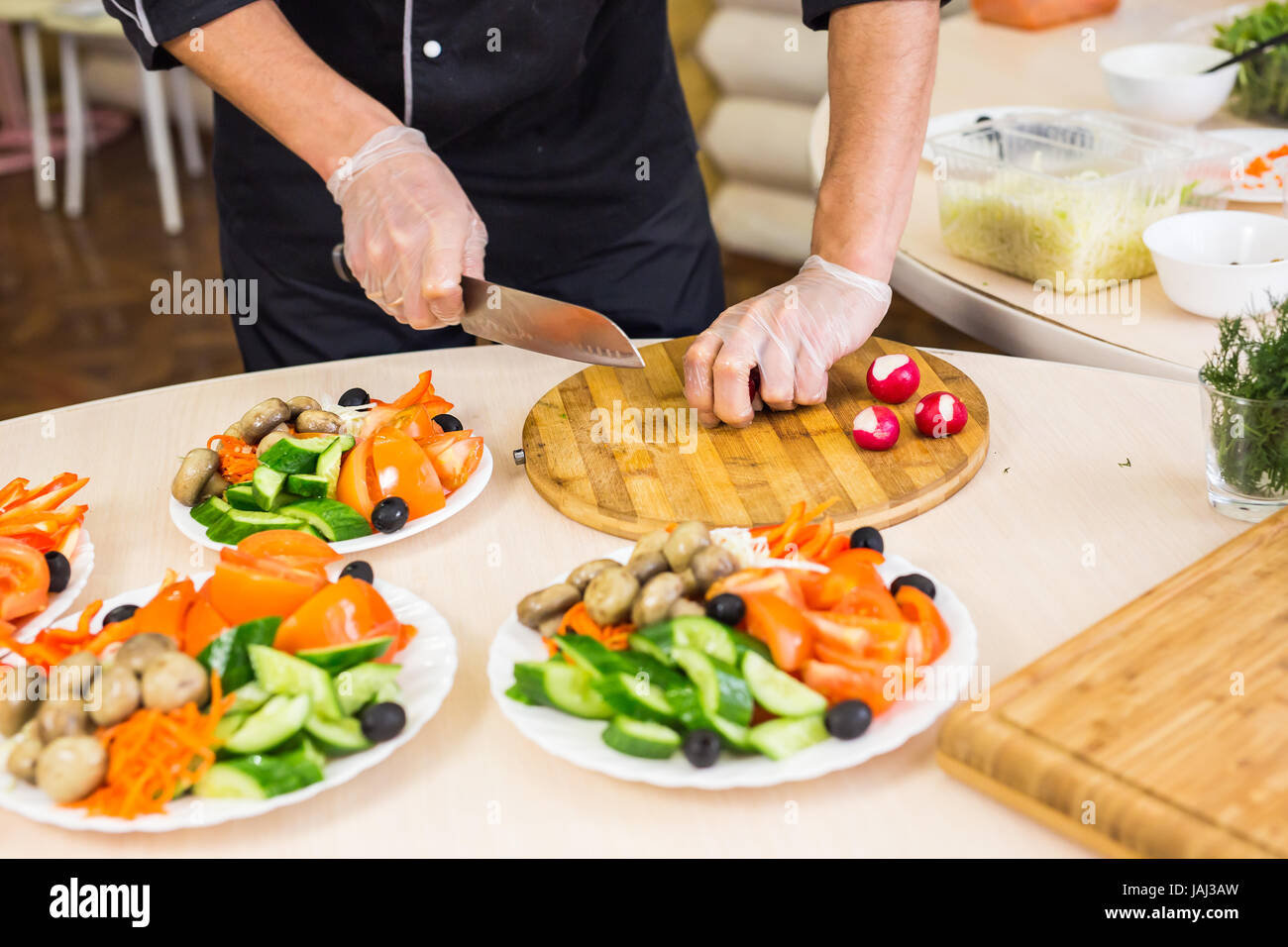 Close-up of chef cooking food kitchen restaurant cutting cook hands ...