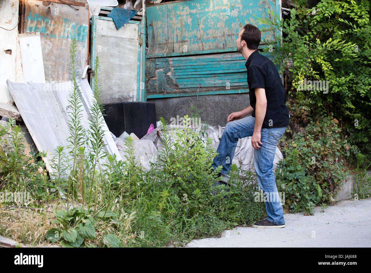 Man and a city. The young man is stealing to an old shed Stock Photo ...