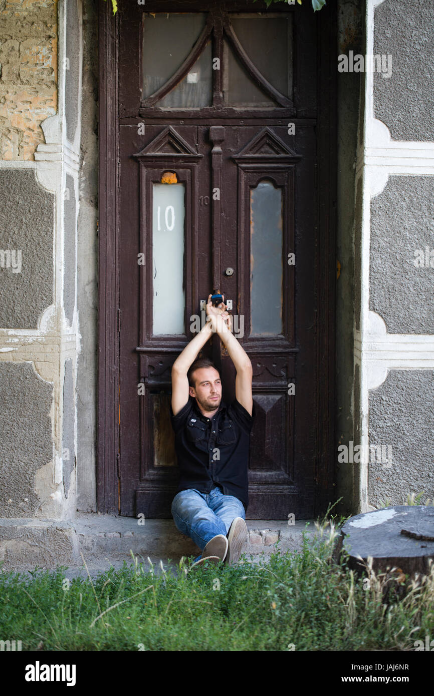 Man and a city. The man is siting to lean against on the door Stock ...