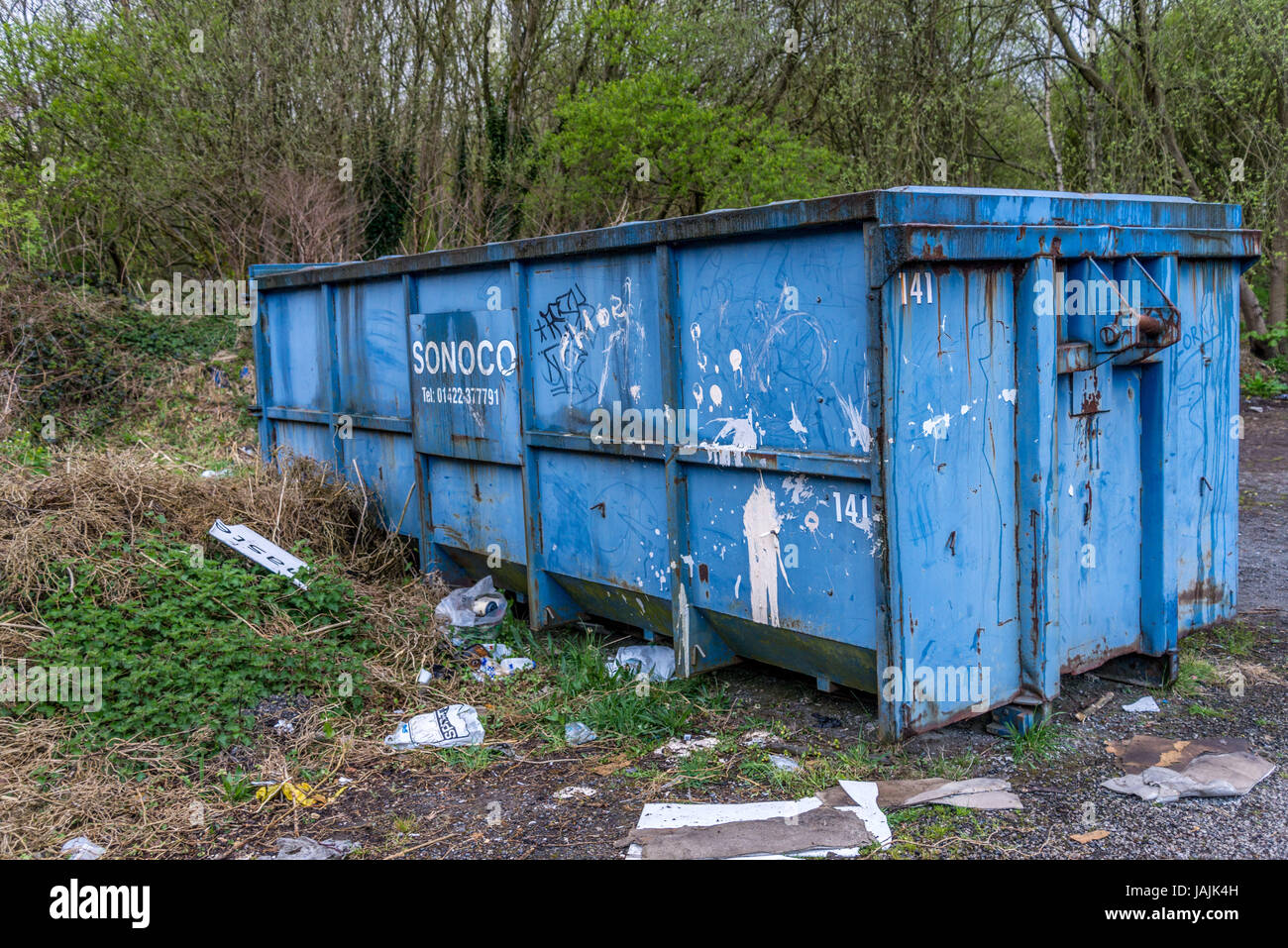 A rusty, blue waste skip standing in woodland Stock Photo - Alamy