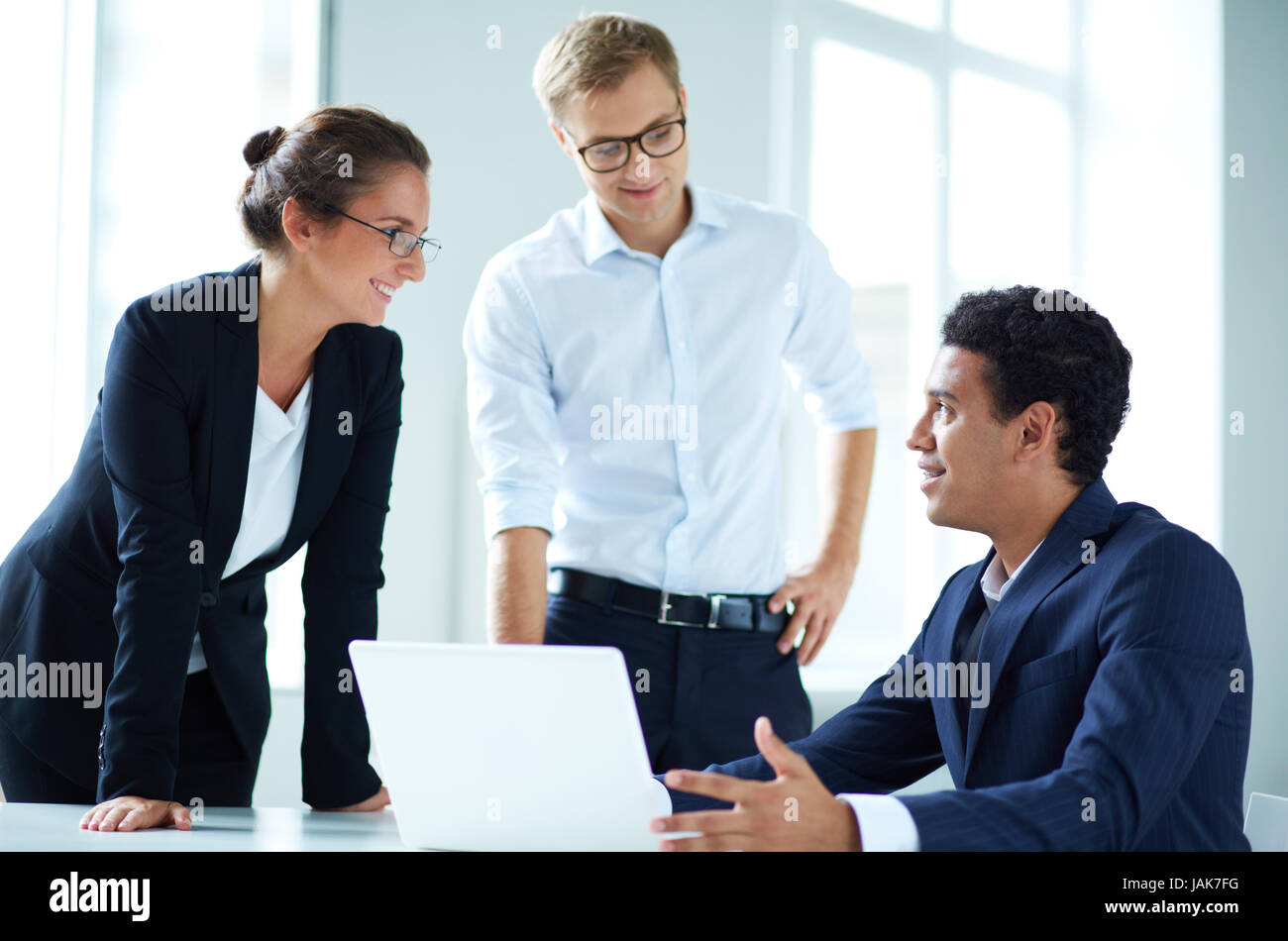 Portrait of smart business partners communicating at meeting Stock ...