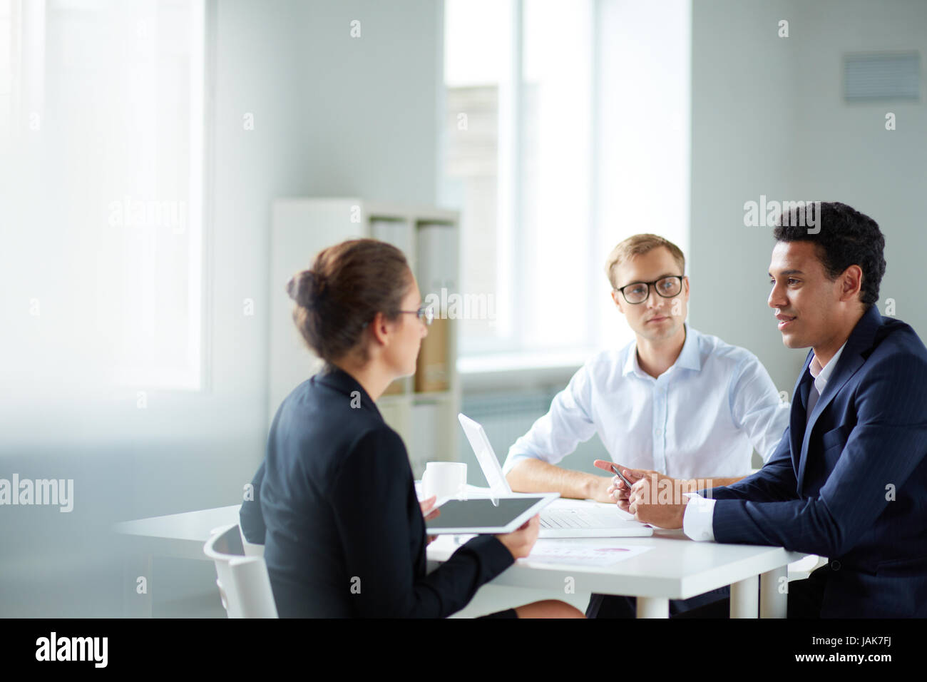 Portrait of smart business partners communicating at meeting Stock ...