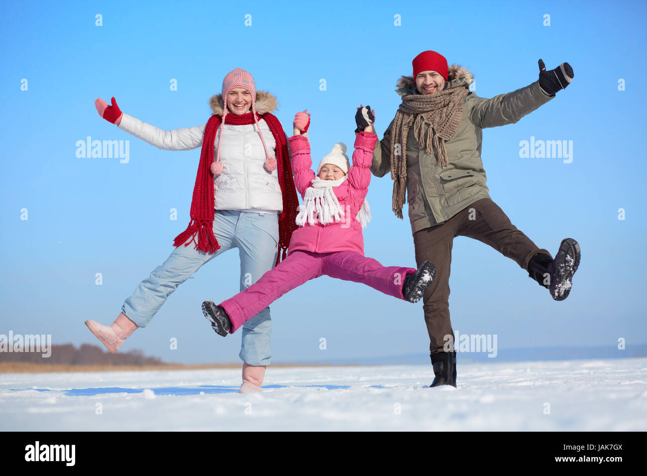 Happy parents and their daughter having fun in winter Stock Photo - Alamy