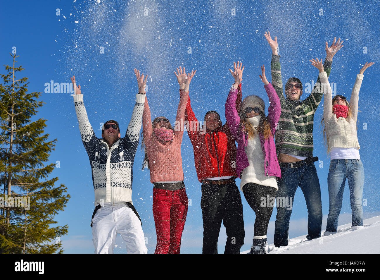 happy friends have fun at winter on fresh snow, healthy young people ...