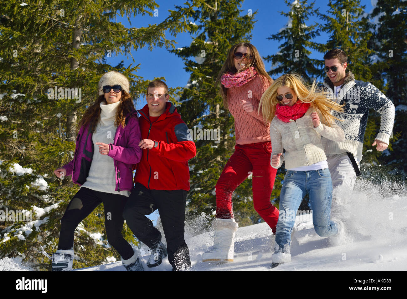 happy friends have fun at winter on fresh snow, healthy young people ...