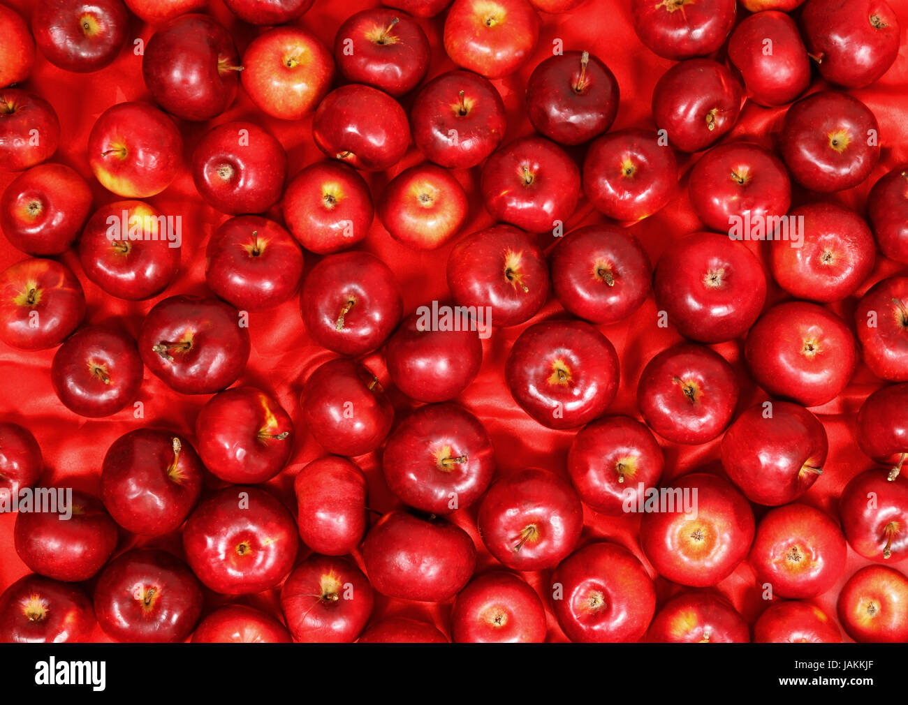 Red apples on red satin fabric, background Stock Photo - Alamy