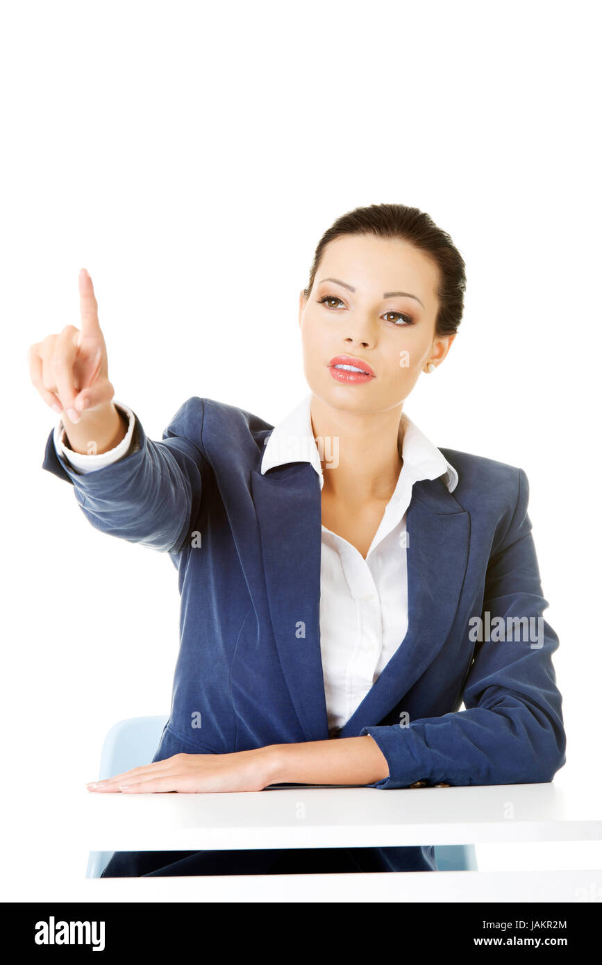 Attractive woman sitting and pointing up. Isolated on white Stock Photo ...