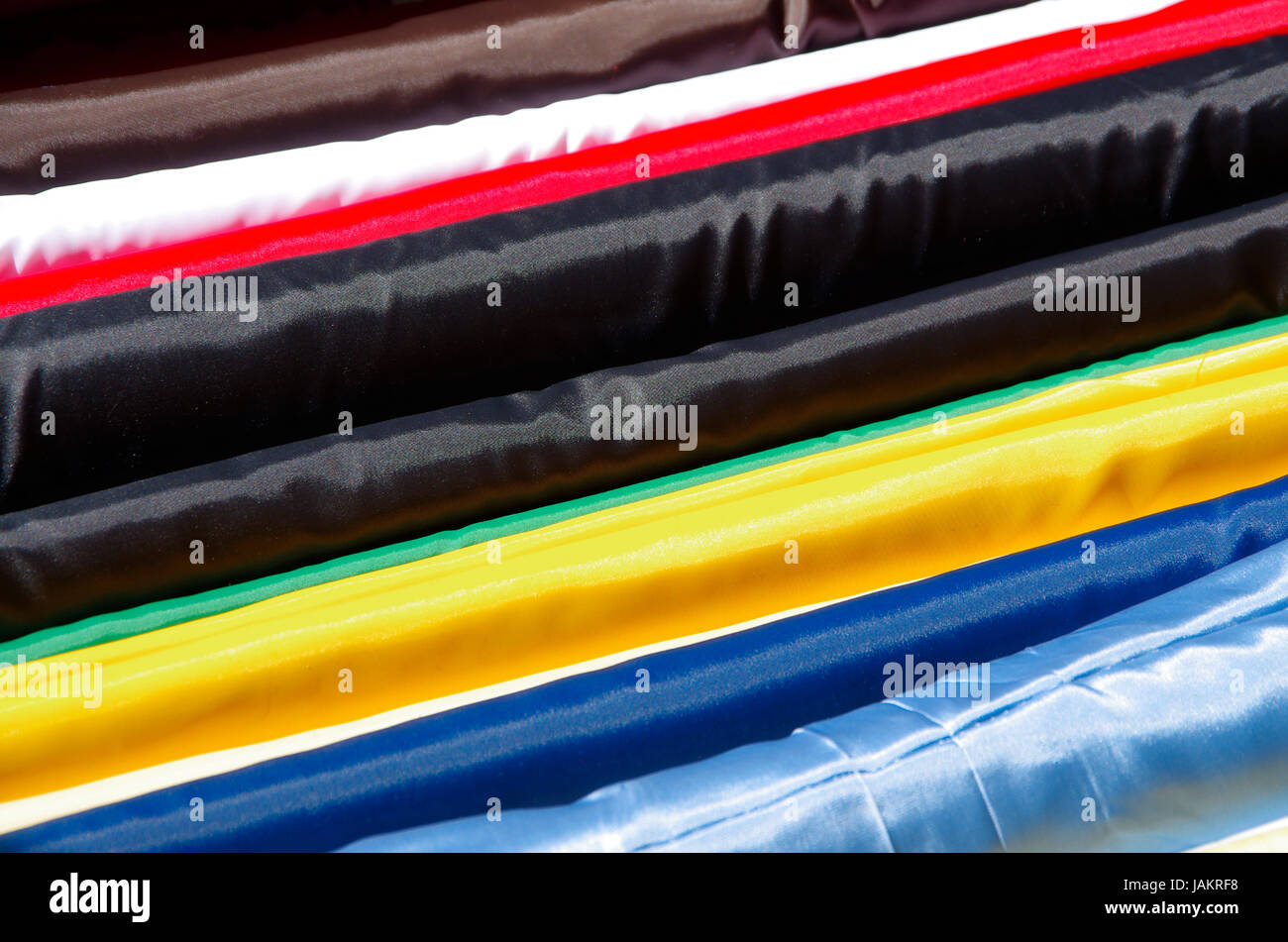 many stacket colorful cloths on the fabric market Stock Photo - Alamy