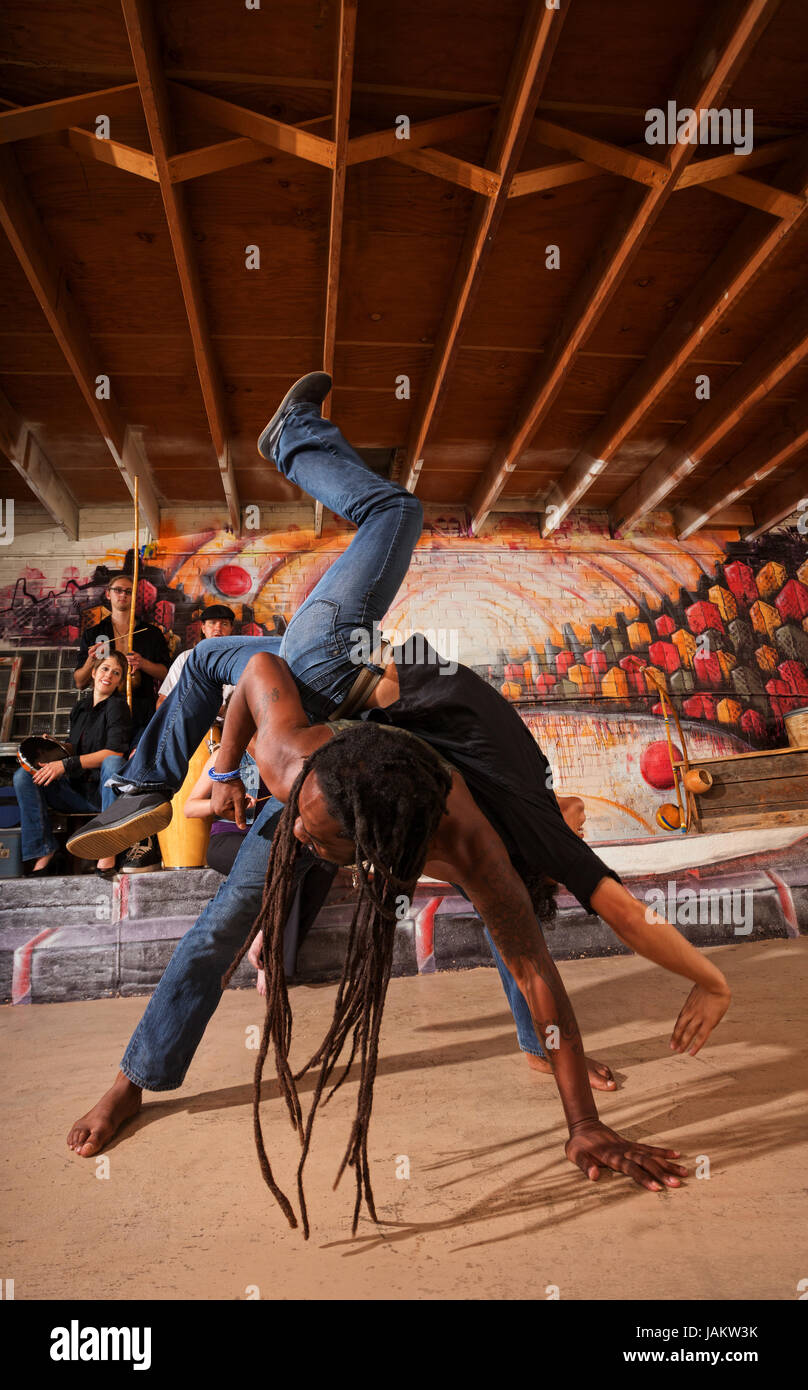 Capoeira partners working out with musicians indoors Stock Photo - Alamy