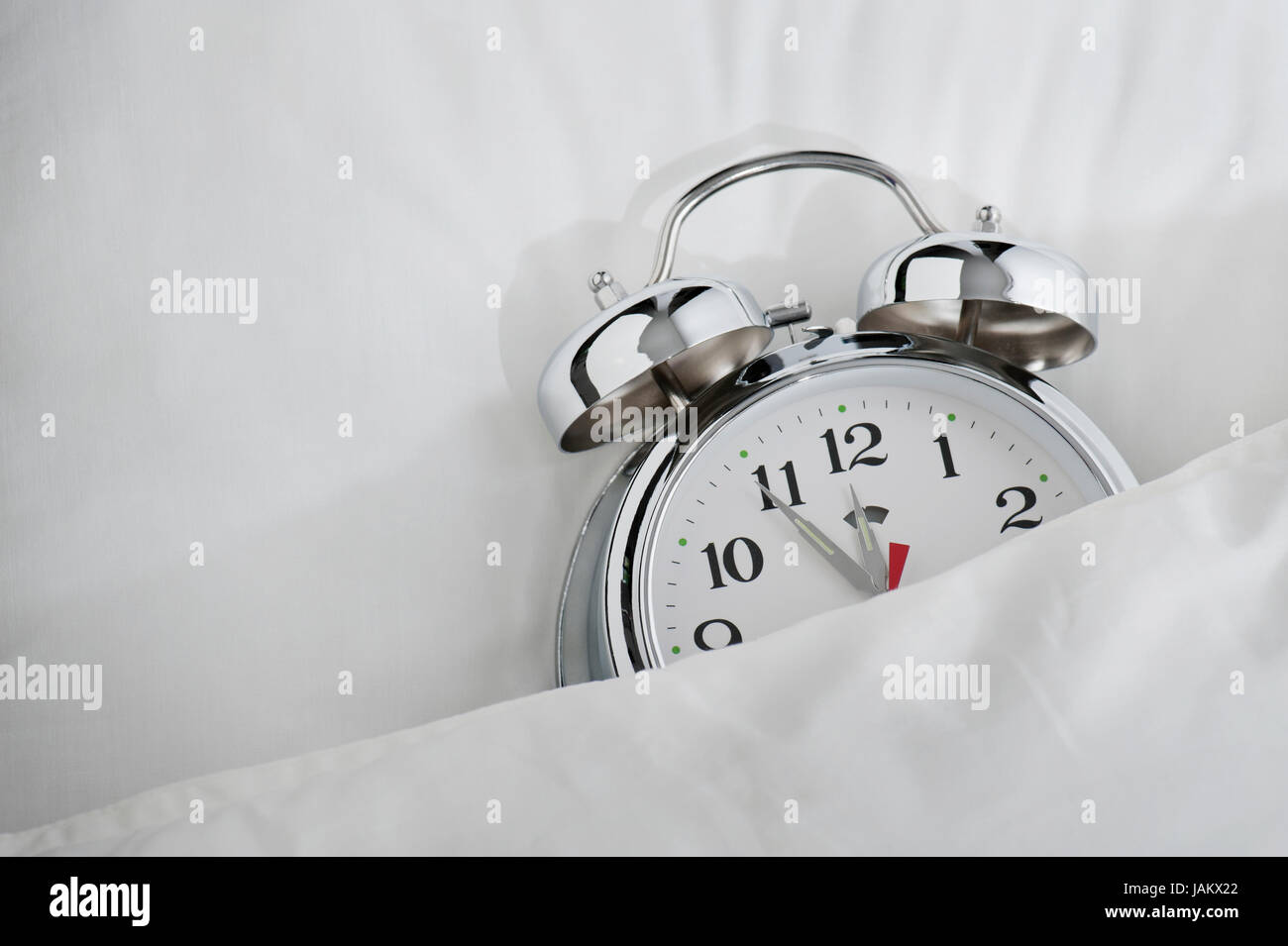 classical alarm clock sleeping on bed until noon Stock Photo - Alamy