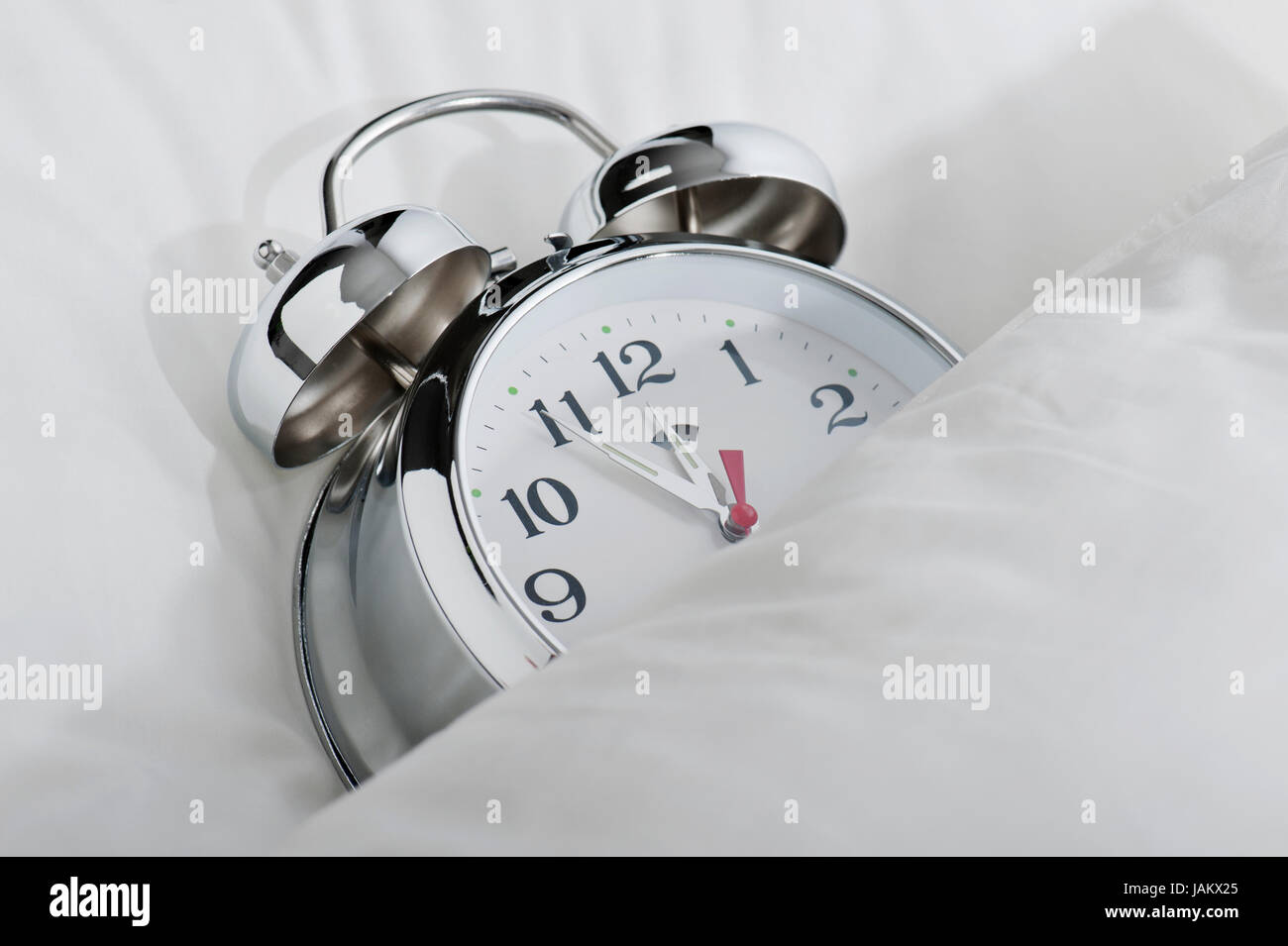 classical alarm clock sleeping on bed until noon Stock Photo - Alamy
