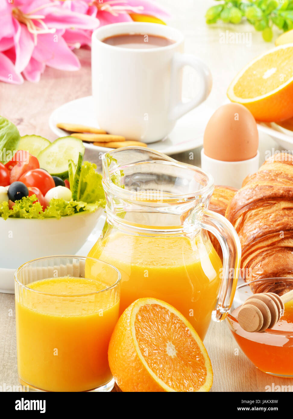 Breakfast with coffee, orange juice, croissant, egg, vegetables and ...