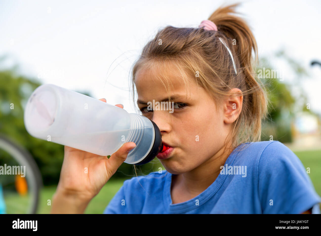 Young girl drinking a glass of plastic Stock Photo - Alamy