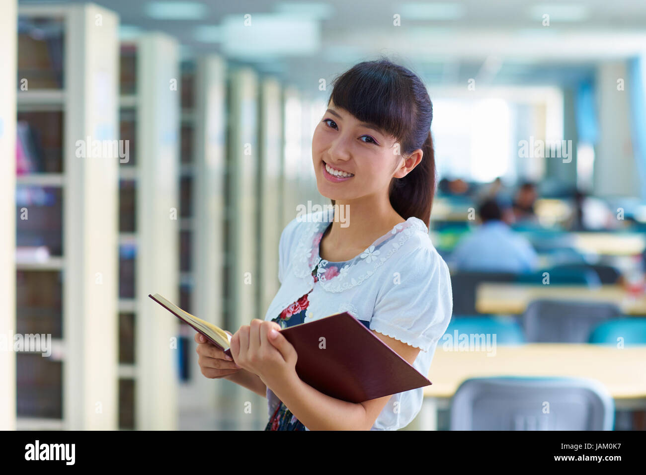 one pretty young Asian or Chinese college student study in the library ...