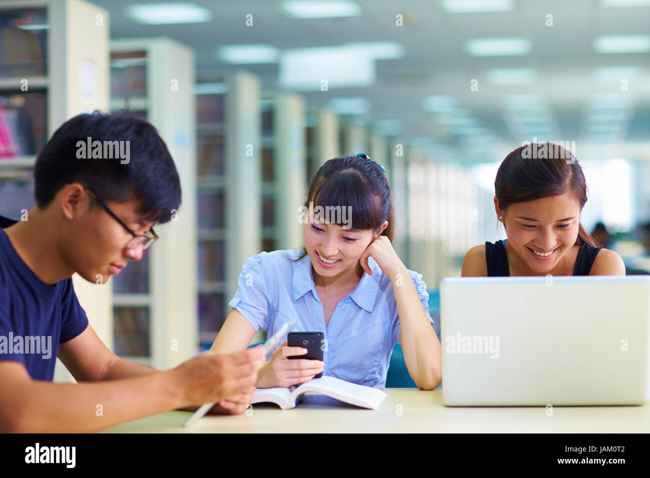 young asian college student using laptop or tablet together in the ...