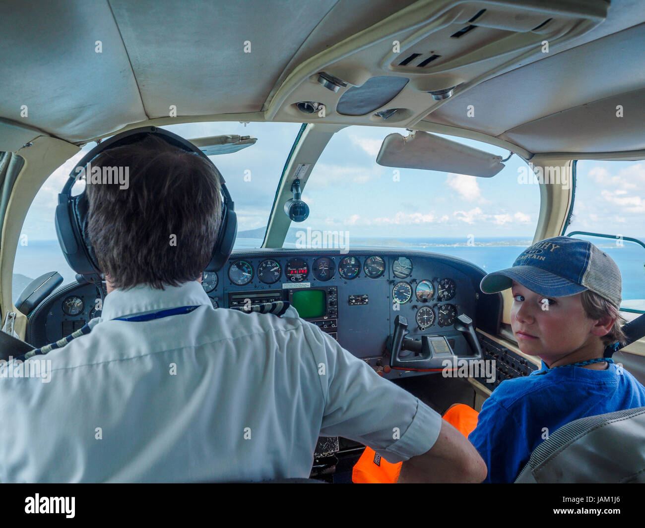 boy copilot in small plane flying over Caribbean islands with pilot ...
