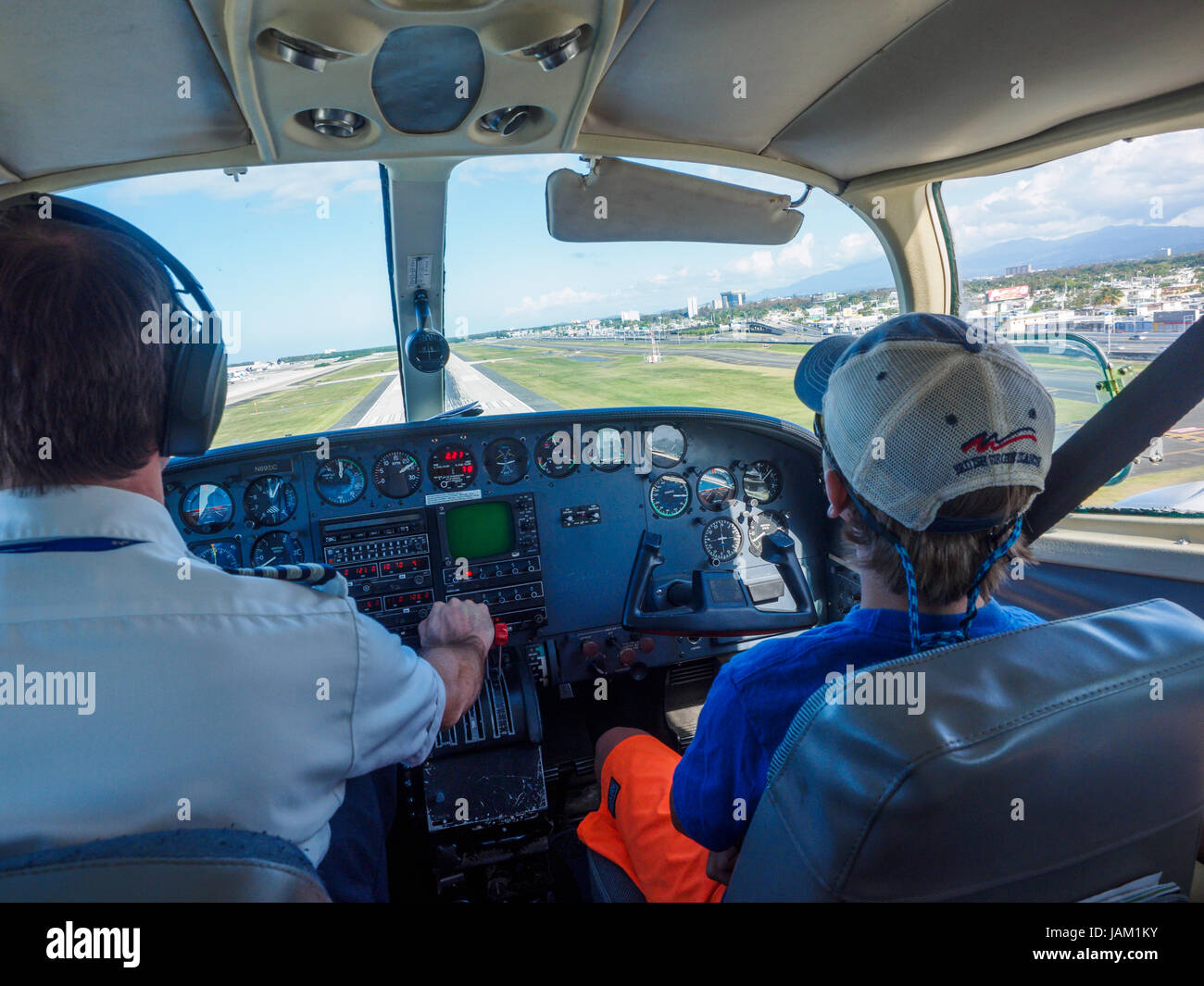 boy copilot in small plane flying over Caribbean islands with pilot ...